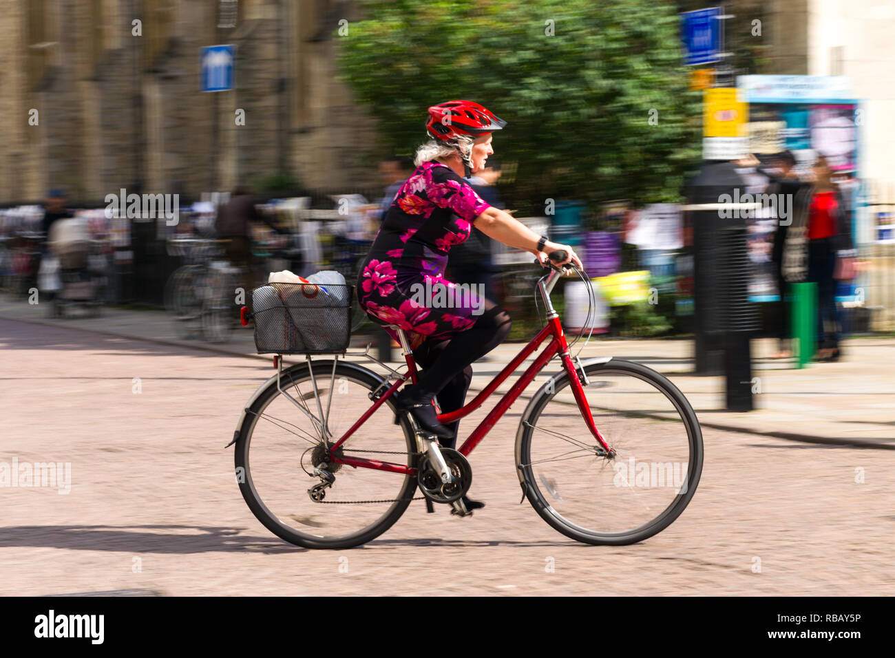 A female cyclist cycles along Kings Parade on a sunny Summer afternoon ...