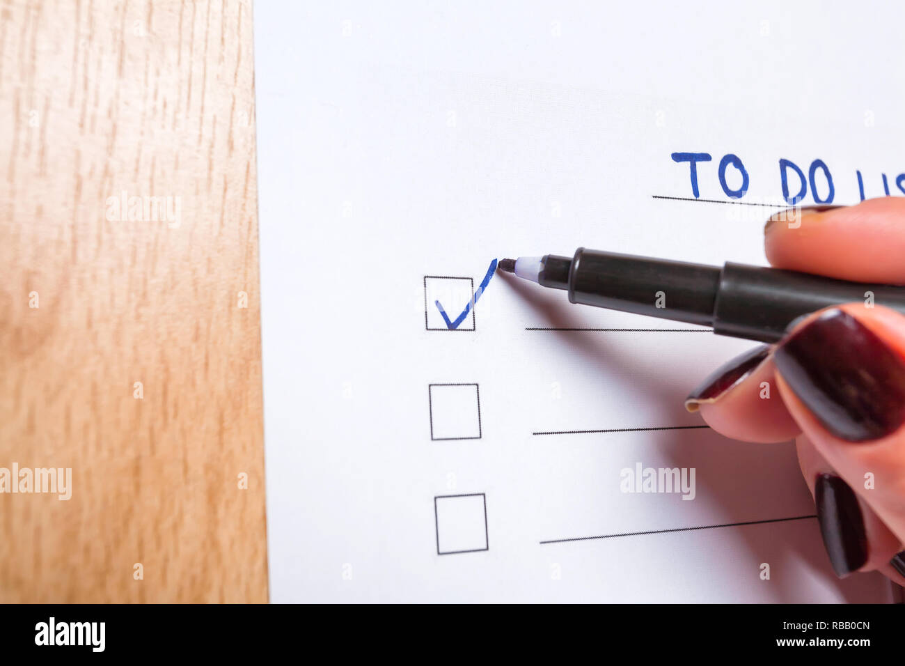 To do checklist on a light floor - girl ticking the box with a marker ...