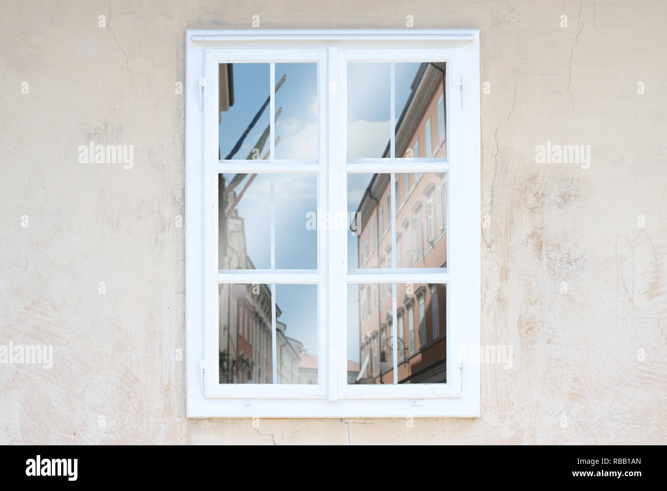 Window on the wall of an old building reflecting the city street Stock ...