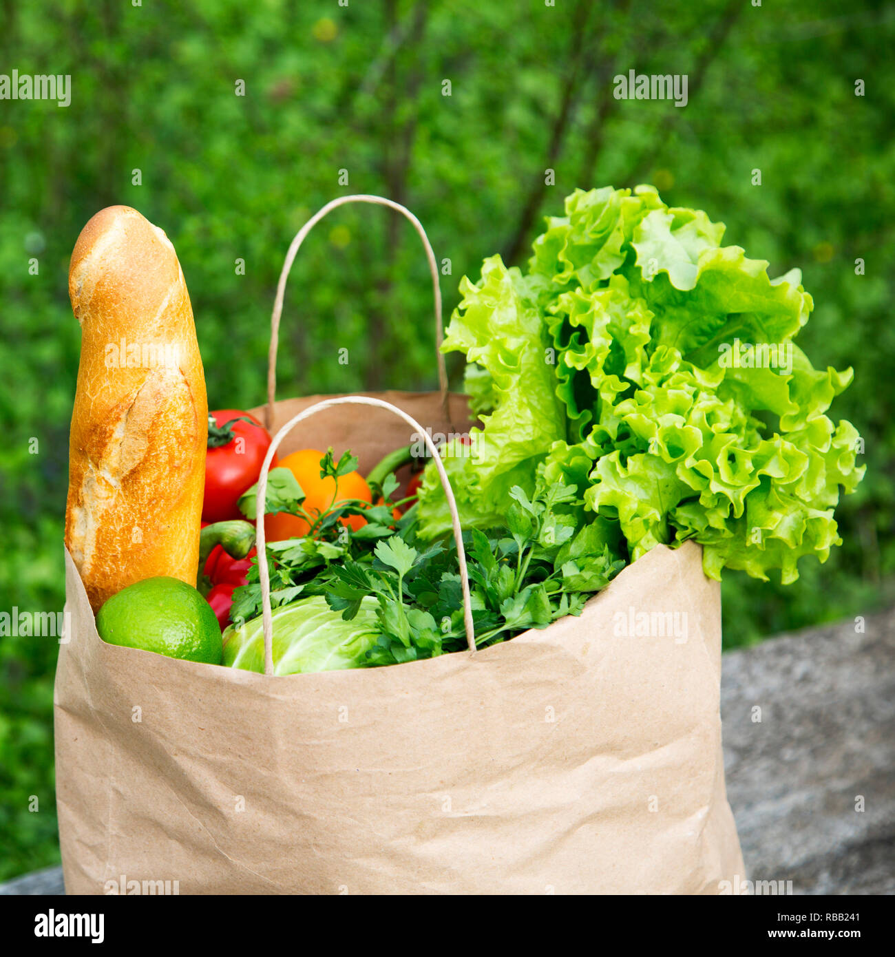 Full paper bag of healthy products stands on the wooden background ...