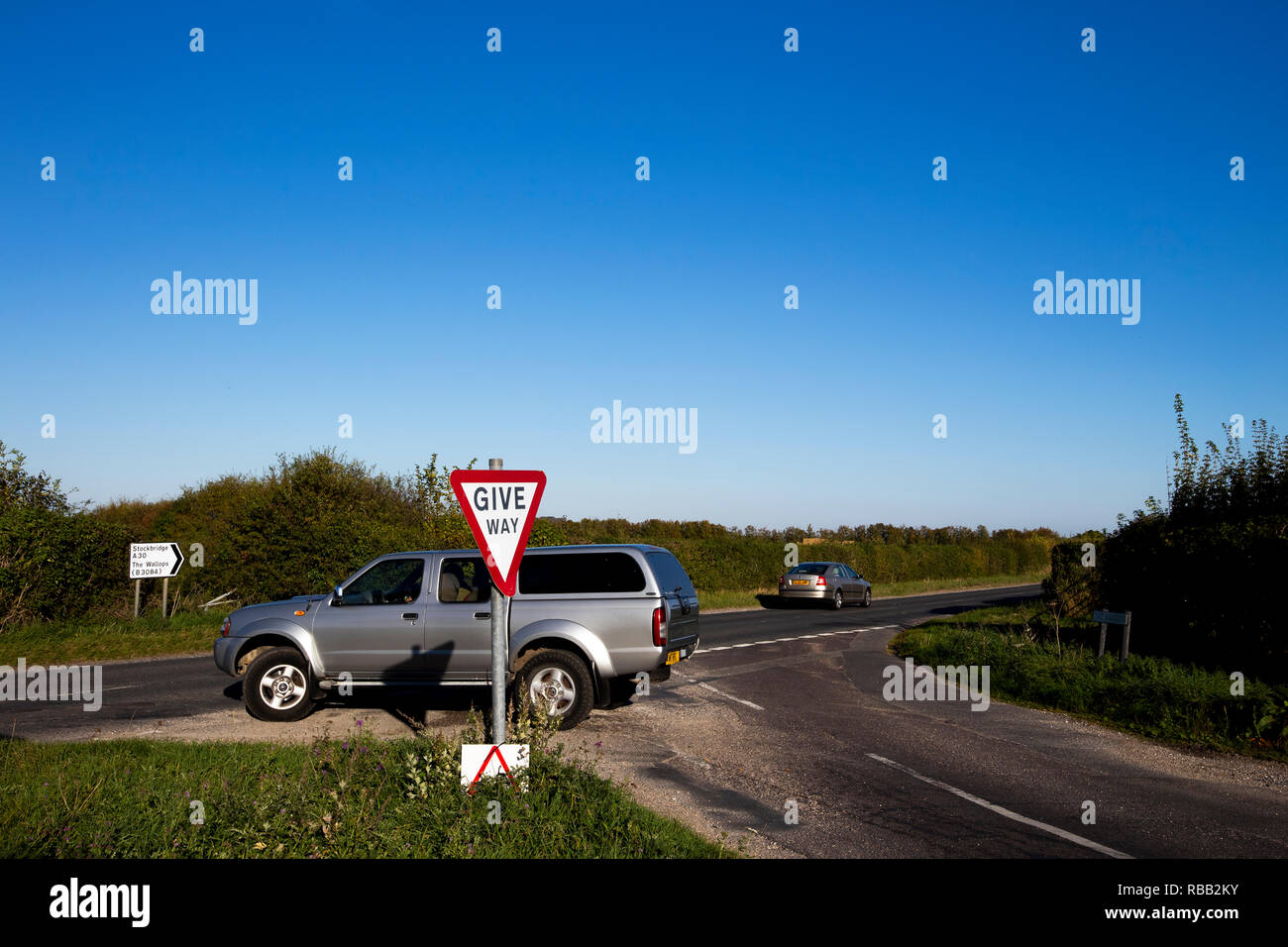 give way road sign on country lane joining main highway junction in ...