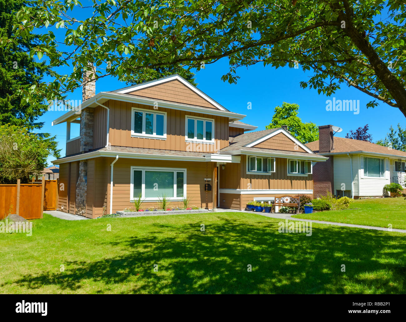 Average family house with big green lawn in front on blue sky ...