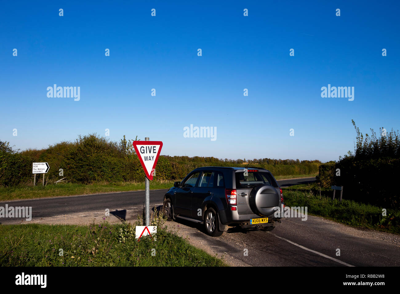 give way road sign on country lane joining main highway junction in ...