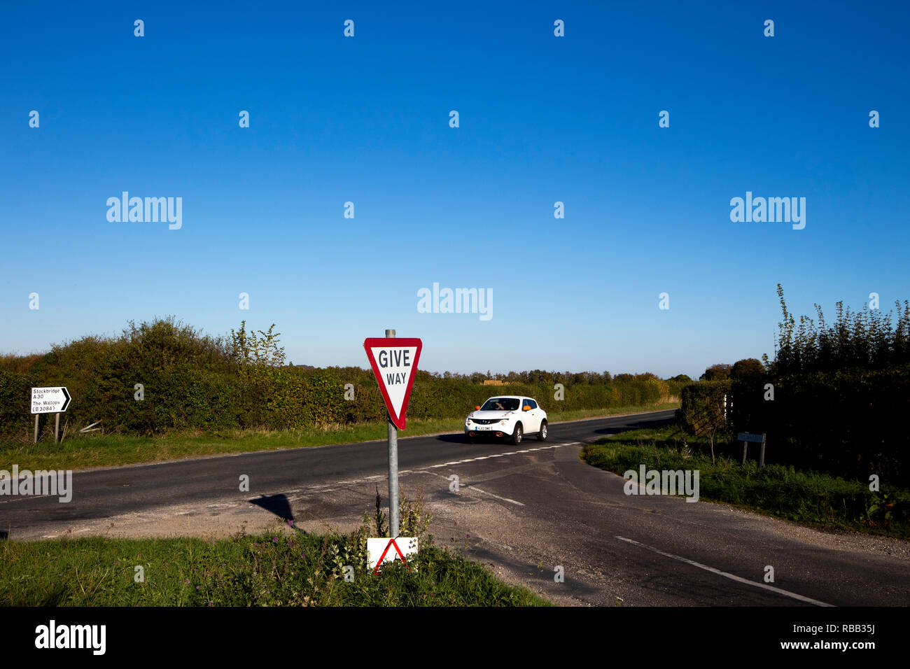 give way road sign on country lane joining main highway junction in ...