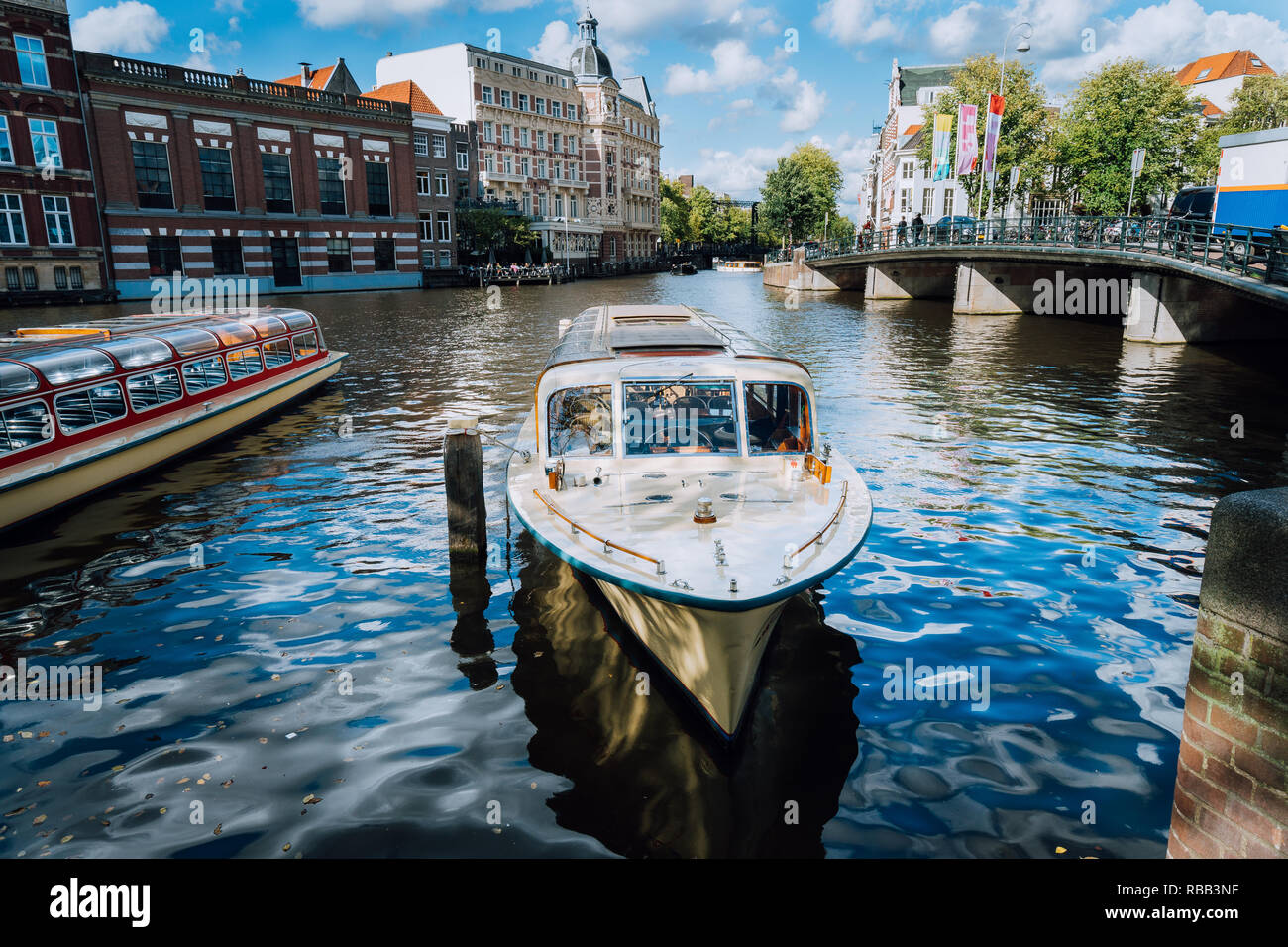 View on the bridge through the river channel with boat in front ...