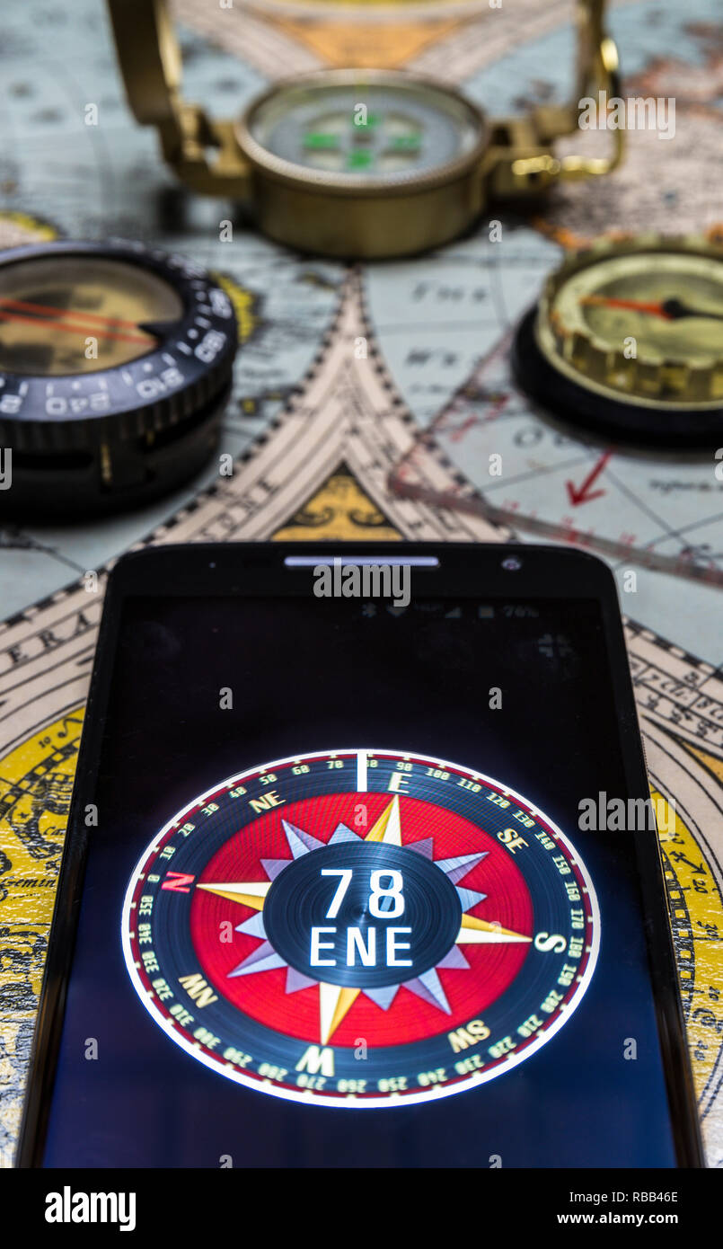 digital compass with analog compasses on old world map as concept Stock ...
