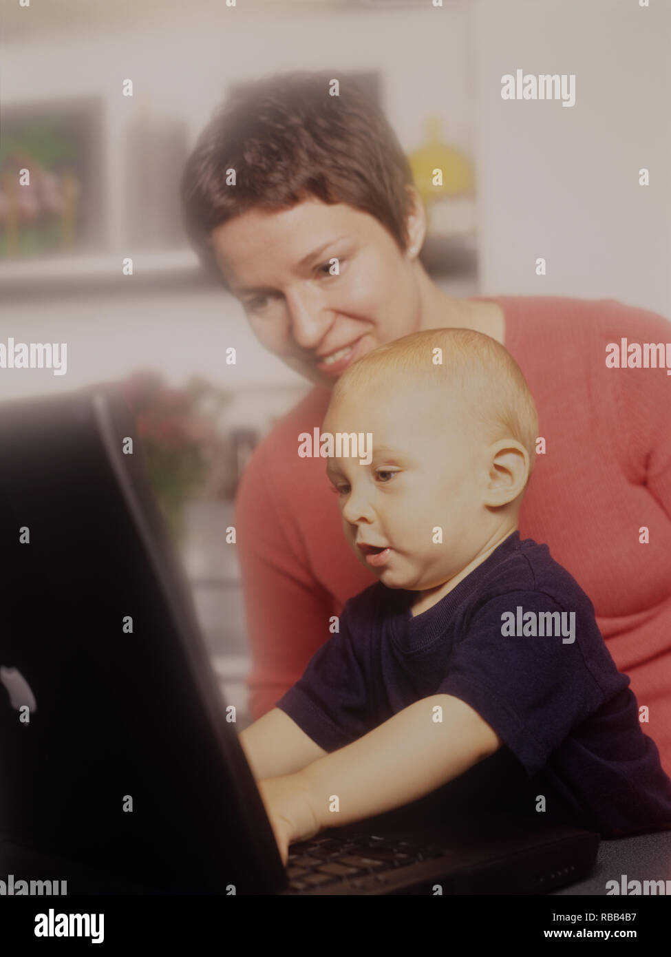 Mother and toddler son on a laptop computer enjoying screen time ...