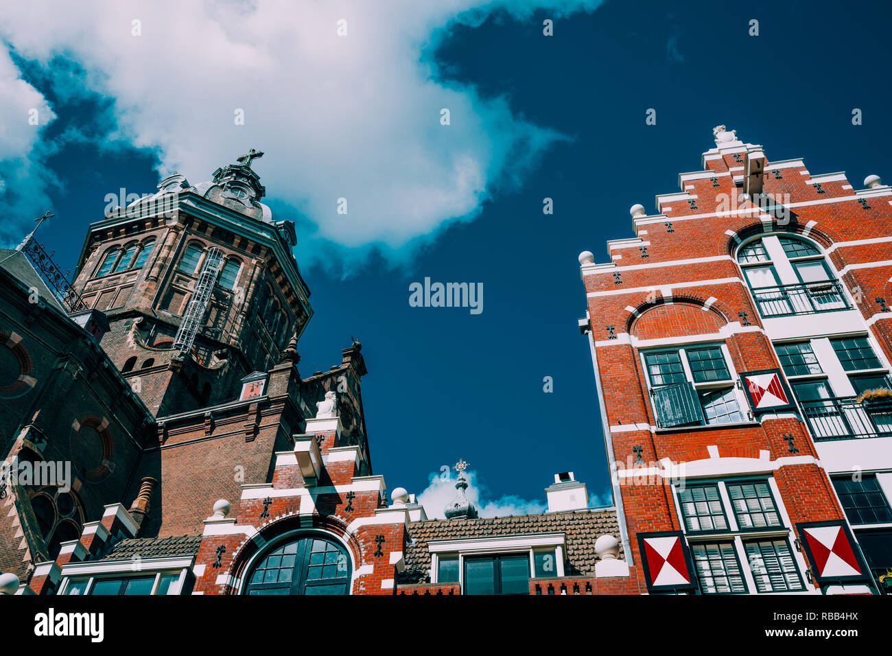 Low angle of traditional dutch house facade and St. Nicolas church in ...