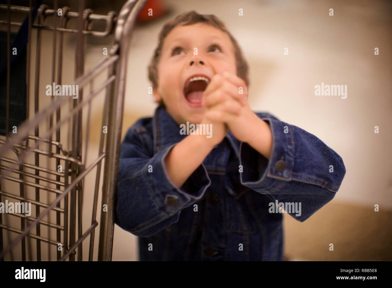 Smiling young boy begging in a supermarket Stock Photo - Alamy