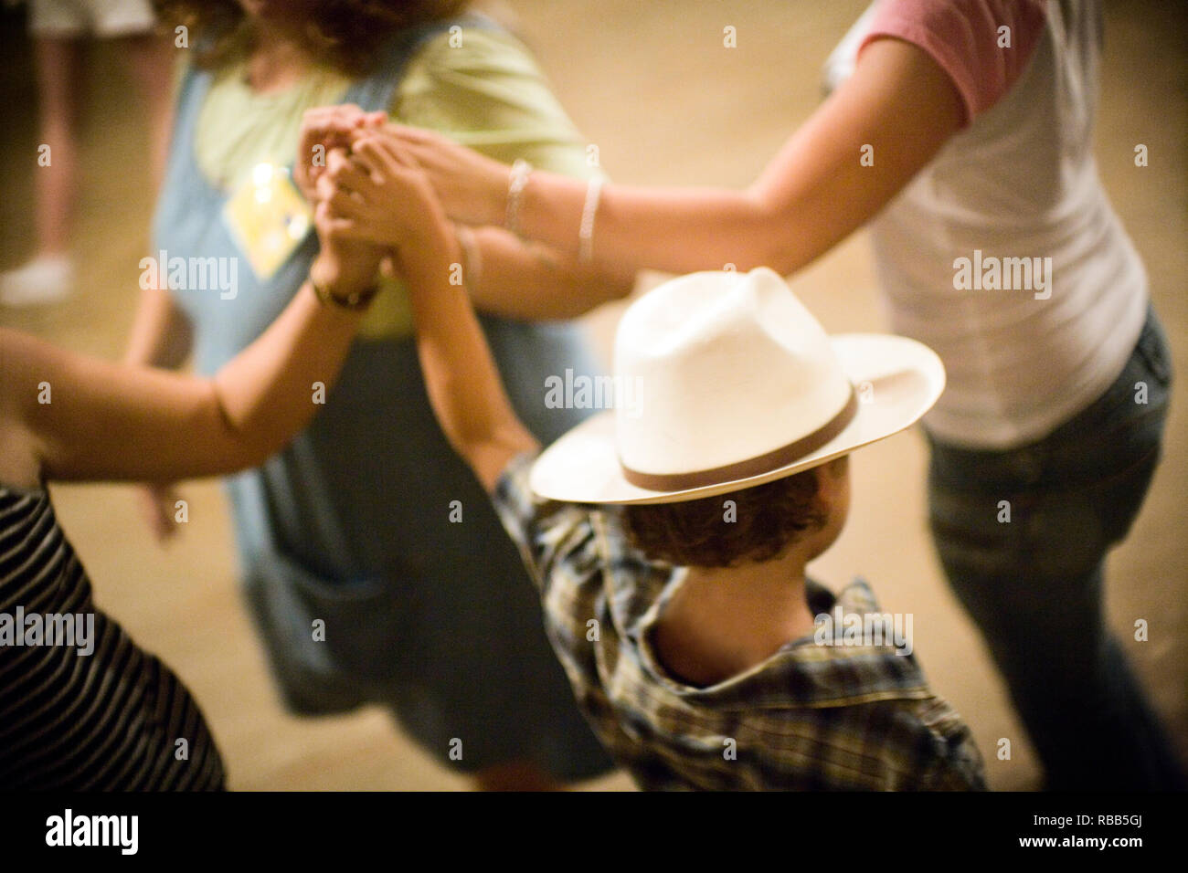 Four people hold hands and move around while playing Stock Photo - Alamy