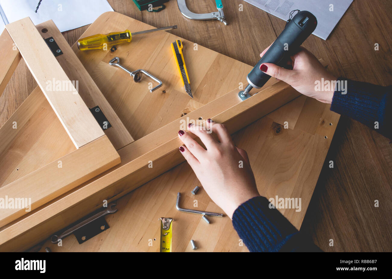Woman Assembly Wooden Furniture Fixing Or Repairing House With