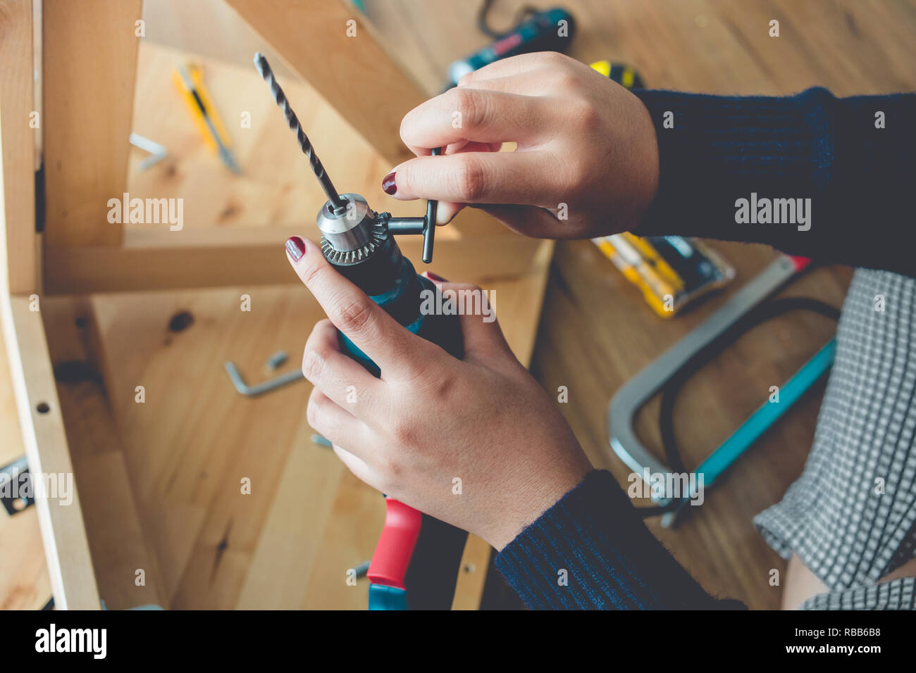 Woman assembly wooden furniture,fixing or repairing house with drill ...