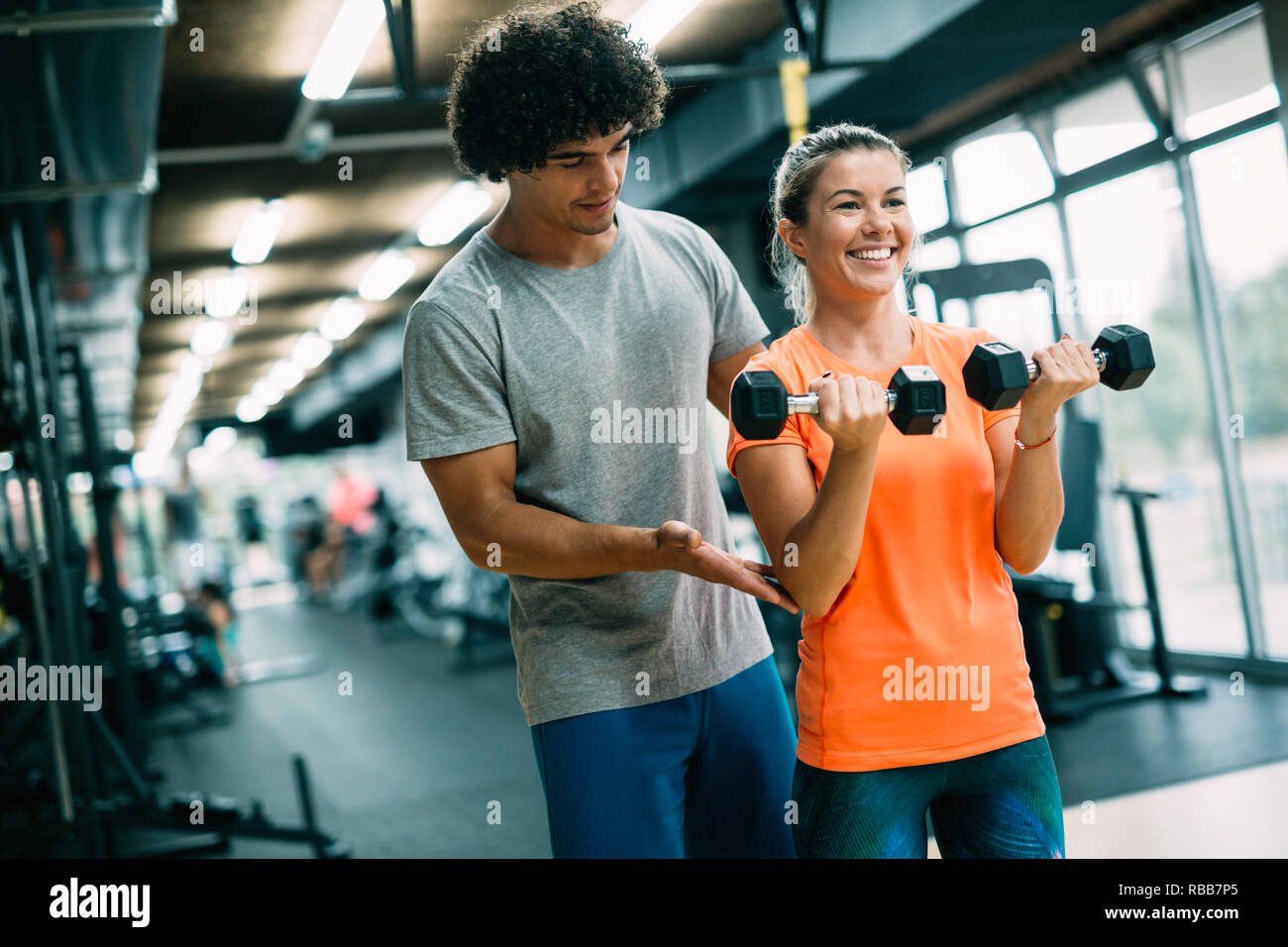 Personal trainer giving instructions in modern gym Stock Photo - Alamy