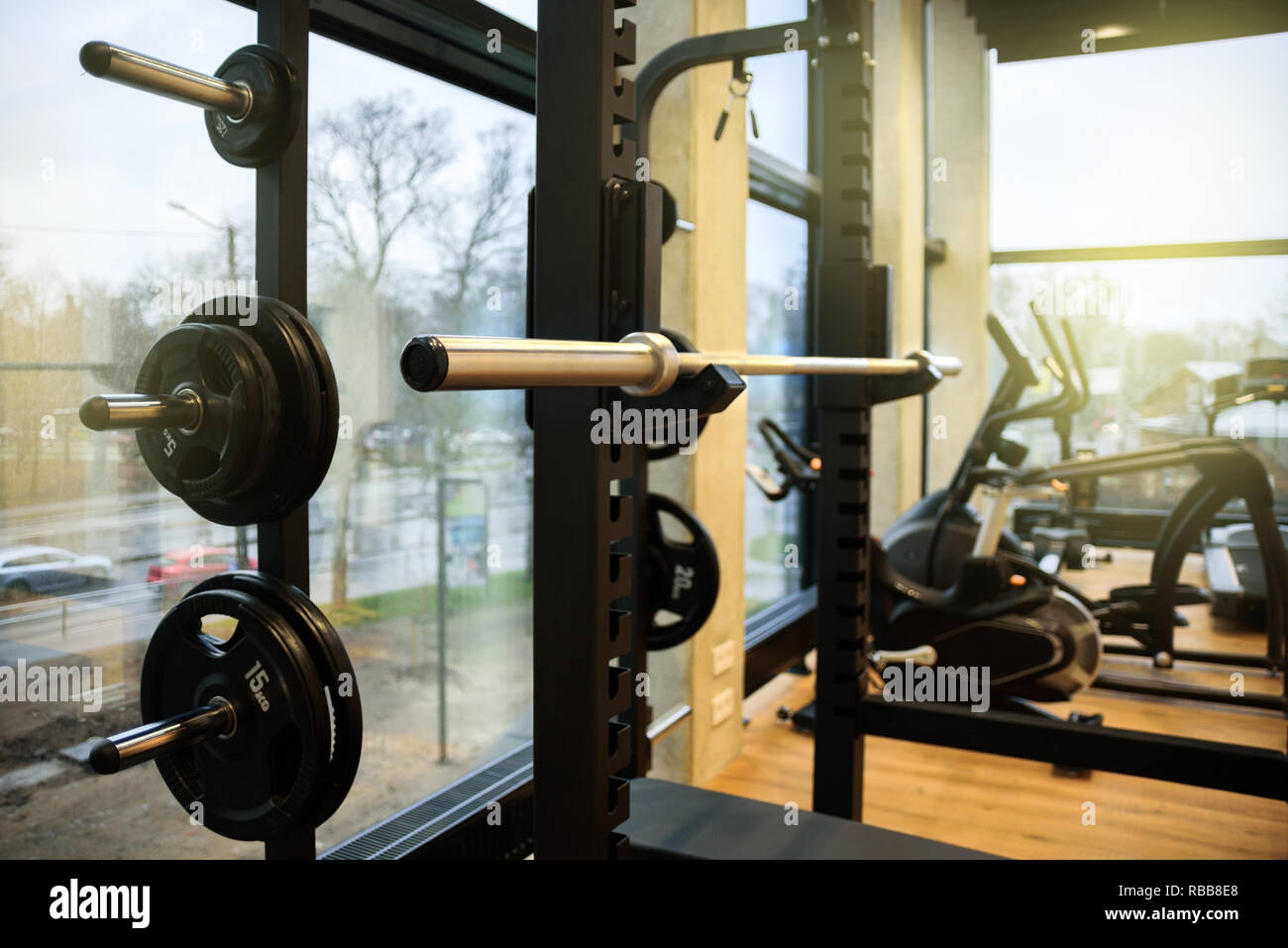 New gym interior with equipments at work office. Barbell rack in focuse ...