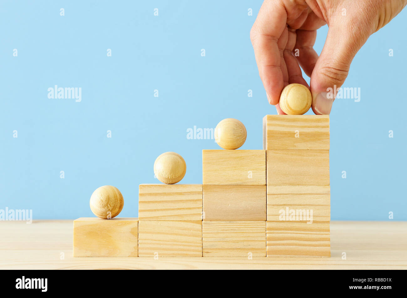 arranging wood blocks stacking as step stairs. success and development ...
