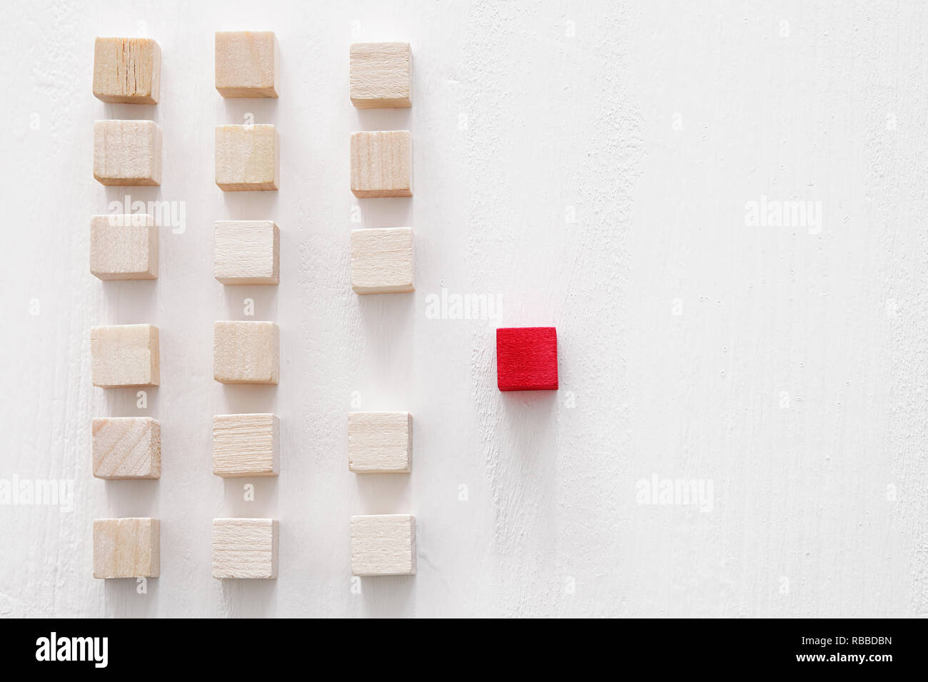 One different red cube block among wooden blocks. Individuality ...