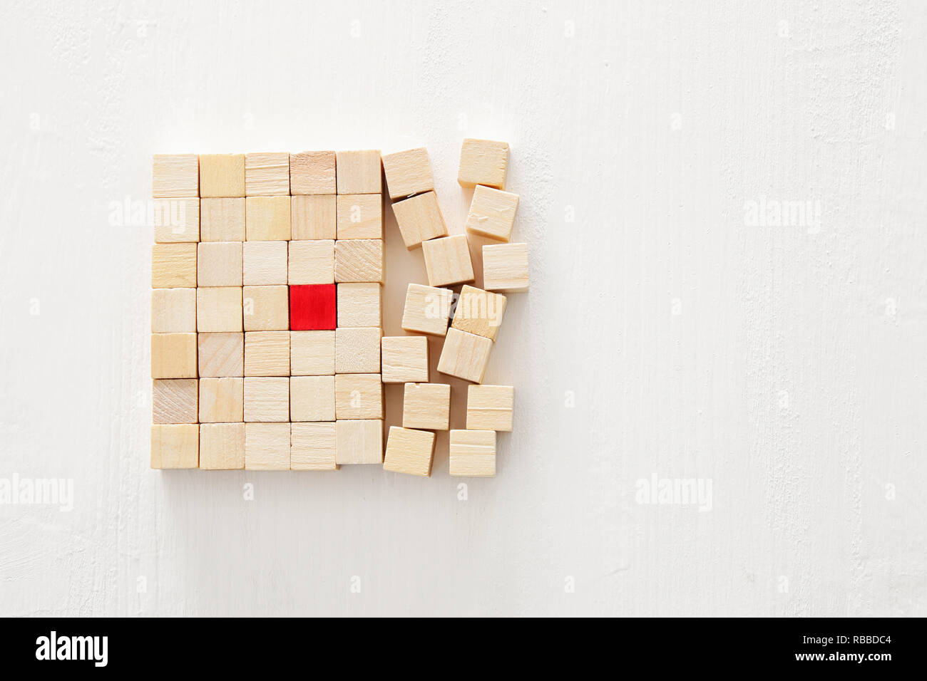One different red cube block among wooden blocks. Individuality ...
