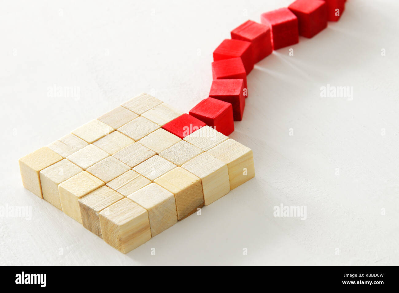 One different red cube block among wooden blocks. Individuality ...