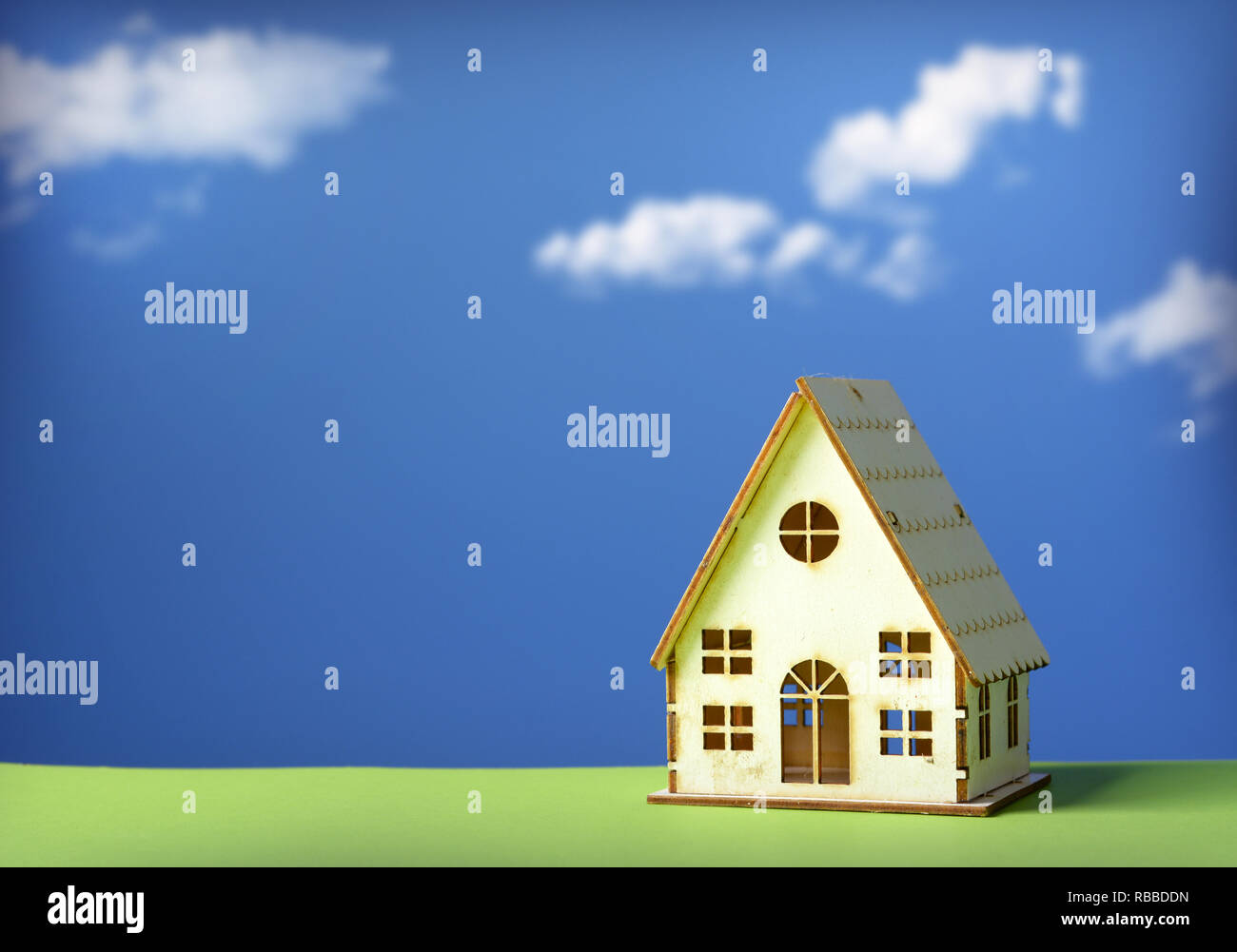 small model of house with blue sky and clouds in the background ...