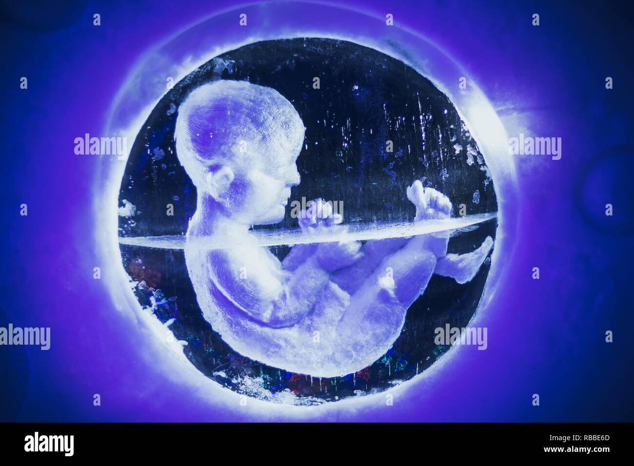 Snow figure of a small child under a layer of cold ice. The figure is ...