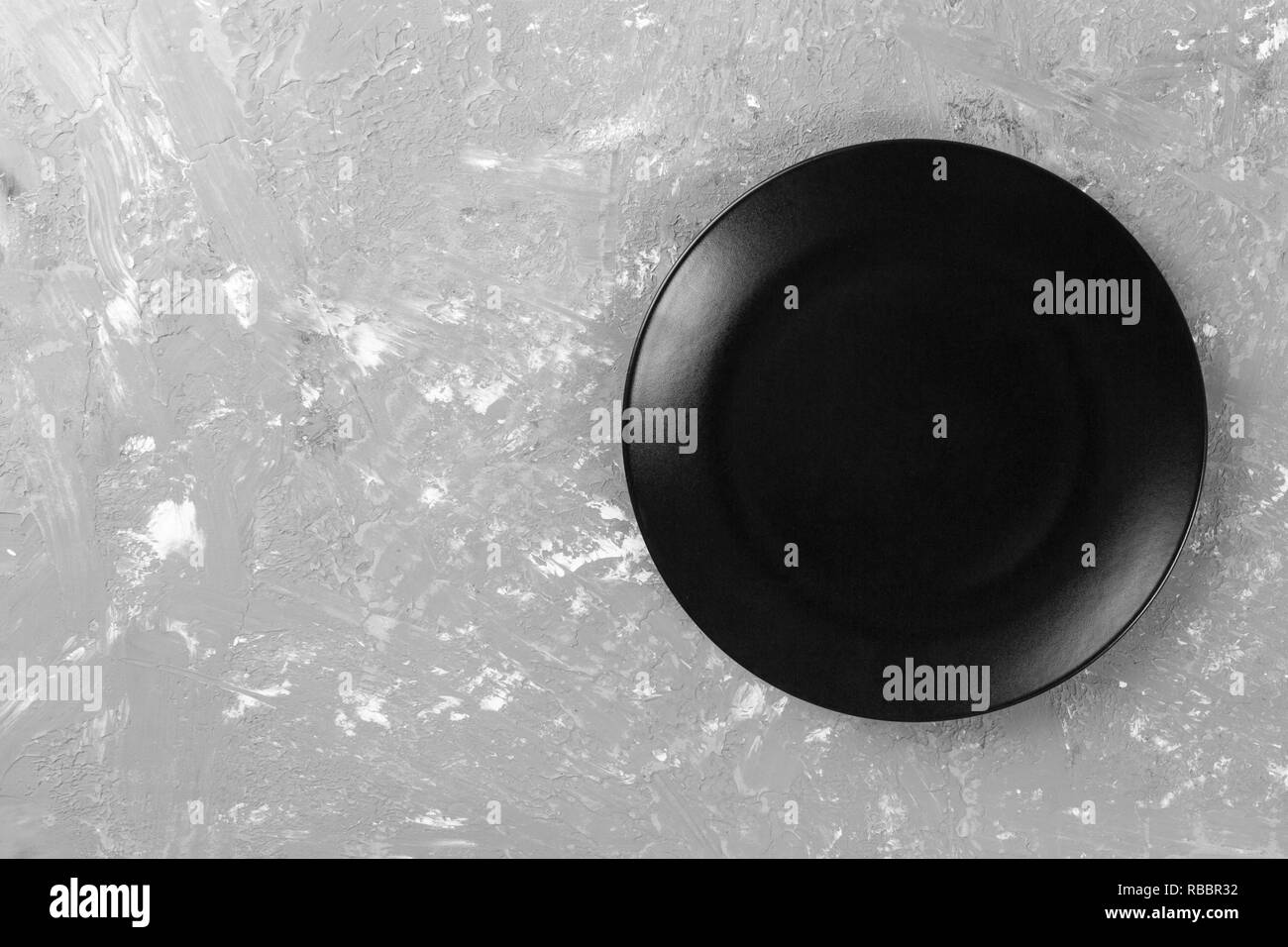 Top view of matte round empty dark dish on dark cement background space ...