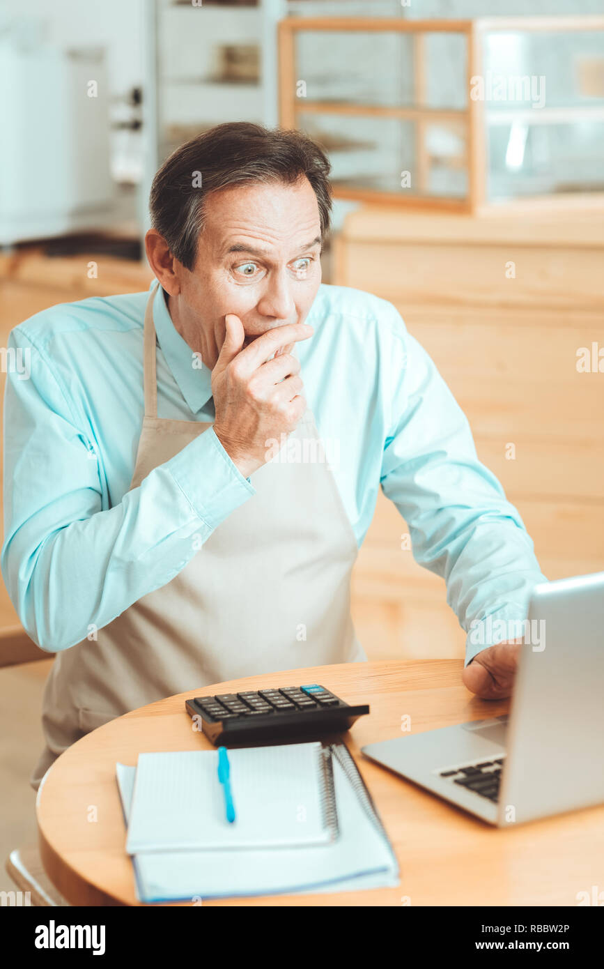 Wow. Handsome middle-aged owner feeling surprised by result of his ...