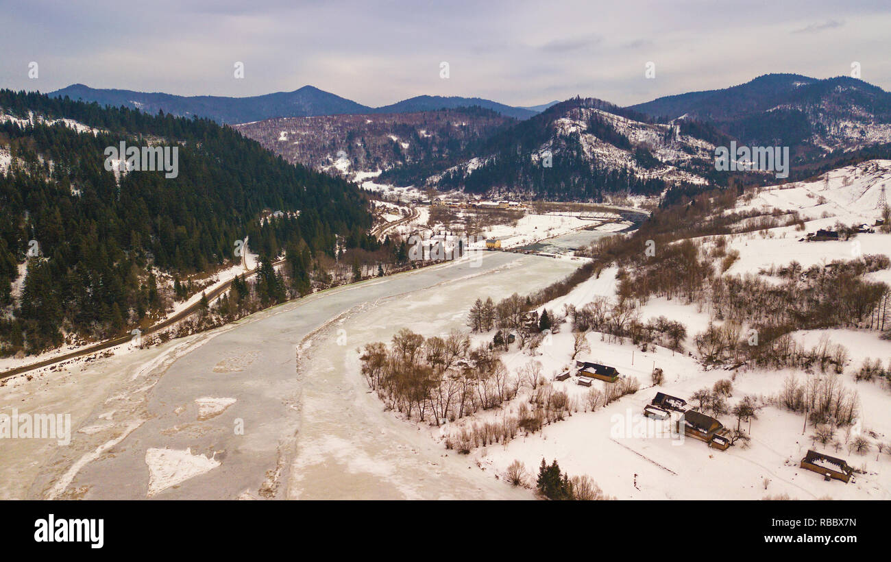 Frozen winter river. Aerial rural view of snowy village and road ...
