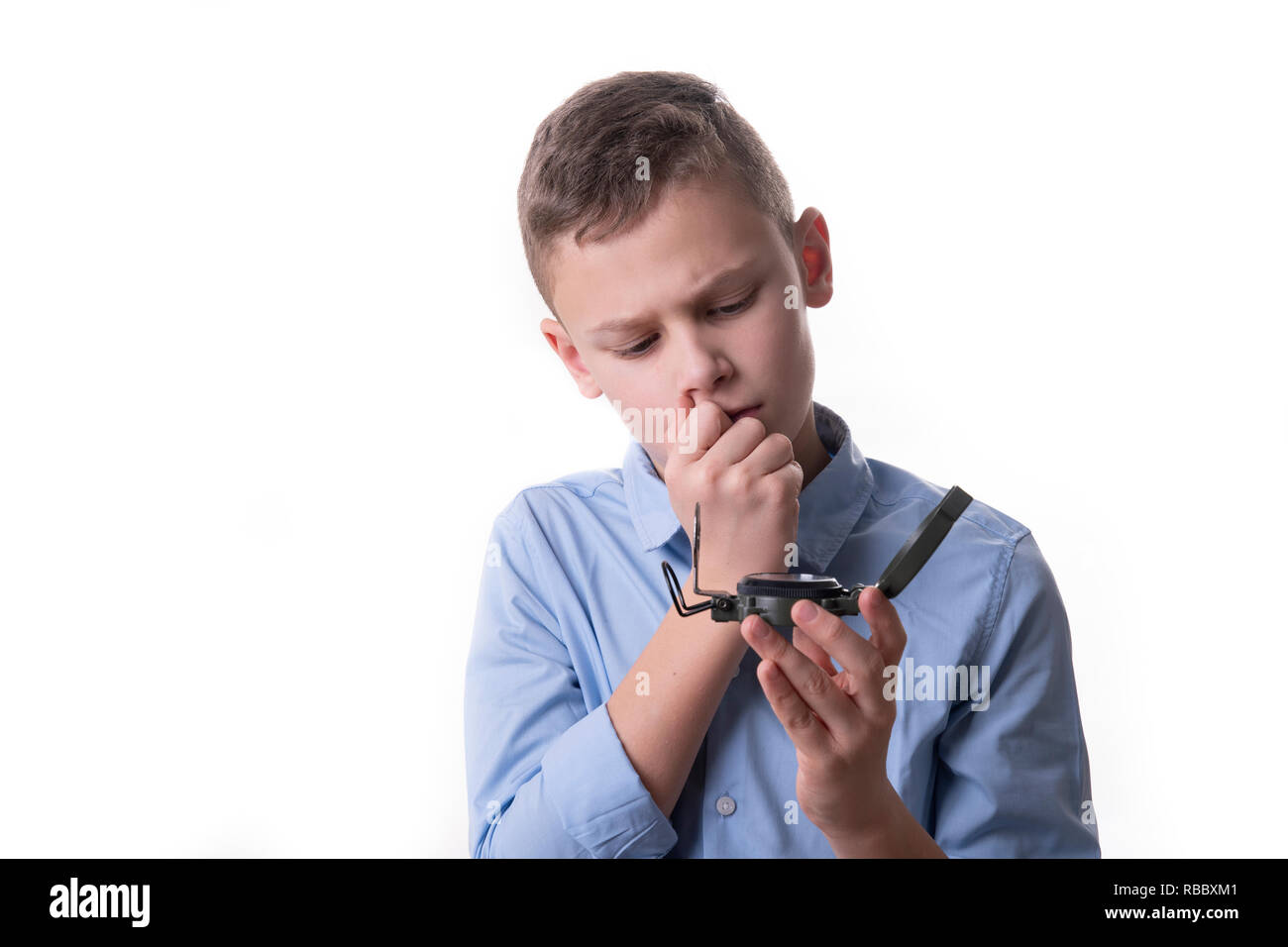 Boy brooding over his future sitting with a compass in his hand and ...