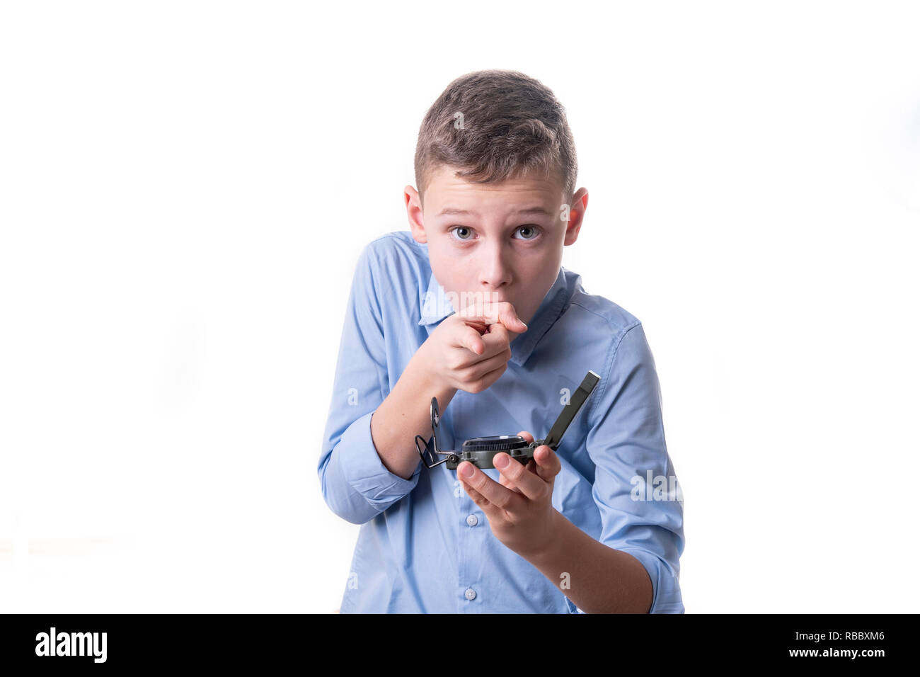 Boy recognizes on a compass in his hand the right direction for the ...