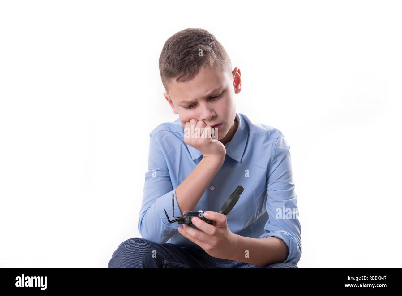 Boy brooding over his future sitting with a compass in his hand and ...