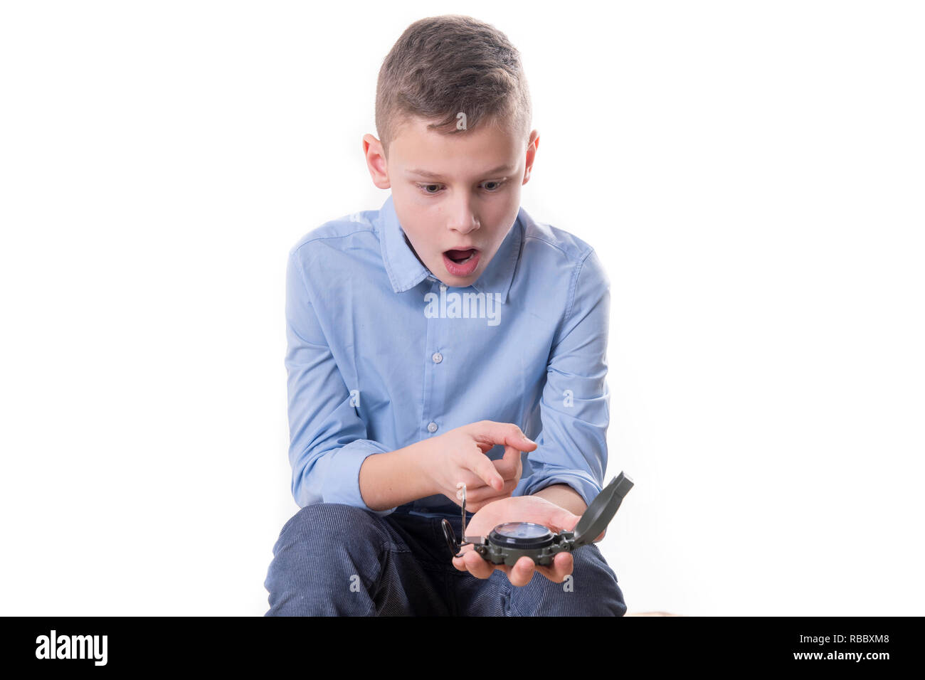 Boy recognizes on a compass in his hand the right direction for the ...