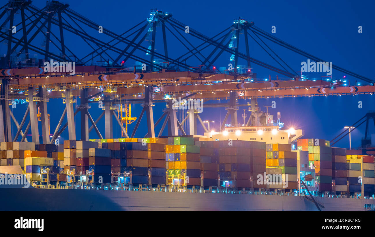 Close up of Container ship unloading at automated harbor terminal in ...