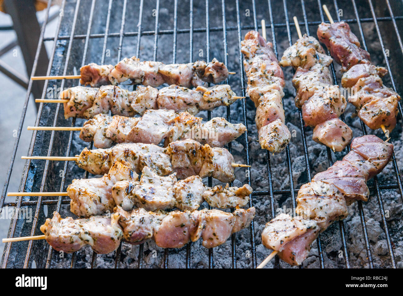Greek souvlaki meat sticks roasting on hot charcoal grill. Traditional ...