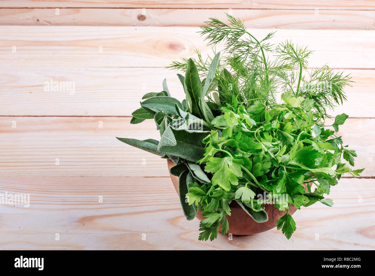 Fresh herb leaves variety in wood bowl on table Stock Photo - Alamy
