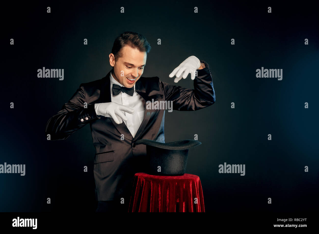 Professional magician wearing suit and gloves standing isolated on ...
