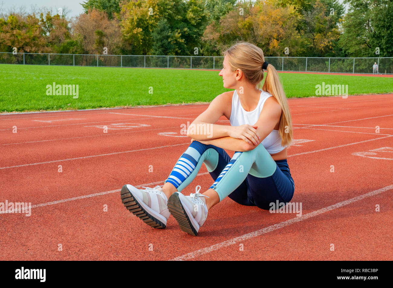 Woman runner taking a rest after run sitting on the running track Stock ...