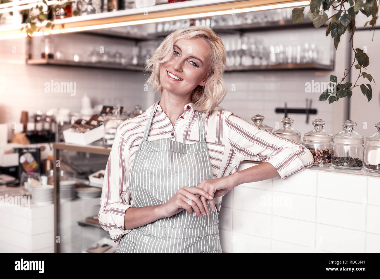 Happy positive woman standing at the counter Stock Photo - Alamy