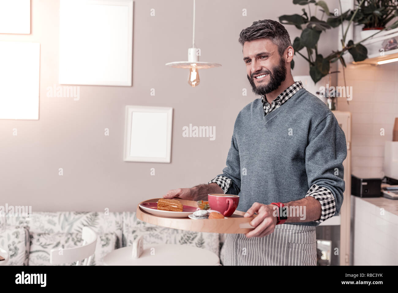 Happy cheerful man bringing food to the table Stock Photo - Alamy