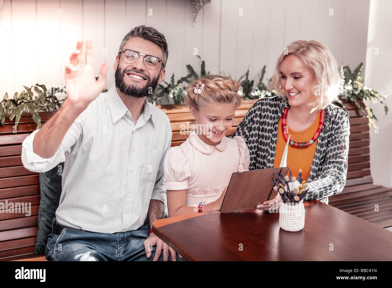Cheerful positive man asking the waitress to come Stock Photo - Alamy Cheerful positive man asking the waitress to come Stock Photo - Alamy