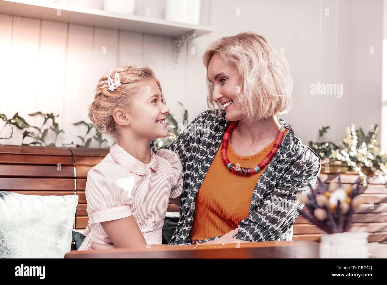 Positive cute girl looking at her mother Stock Photo - Alamy