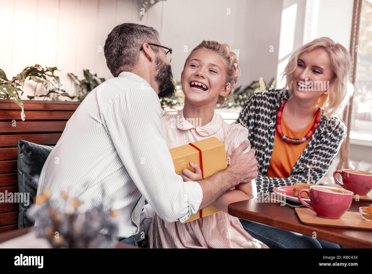 Nice delighted young man hugging his daughter Stock Photo - Alamy