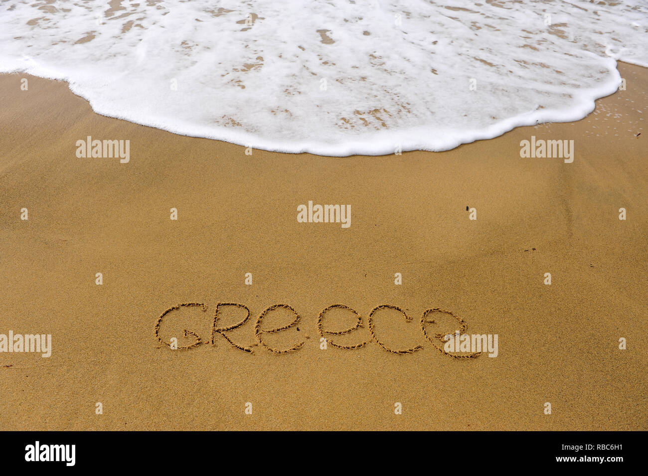 Greece beach sign with waves and sand on background Stock Photo - Alamy
