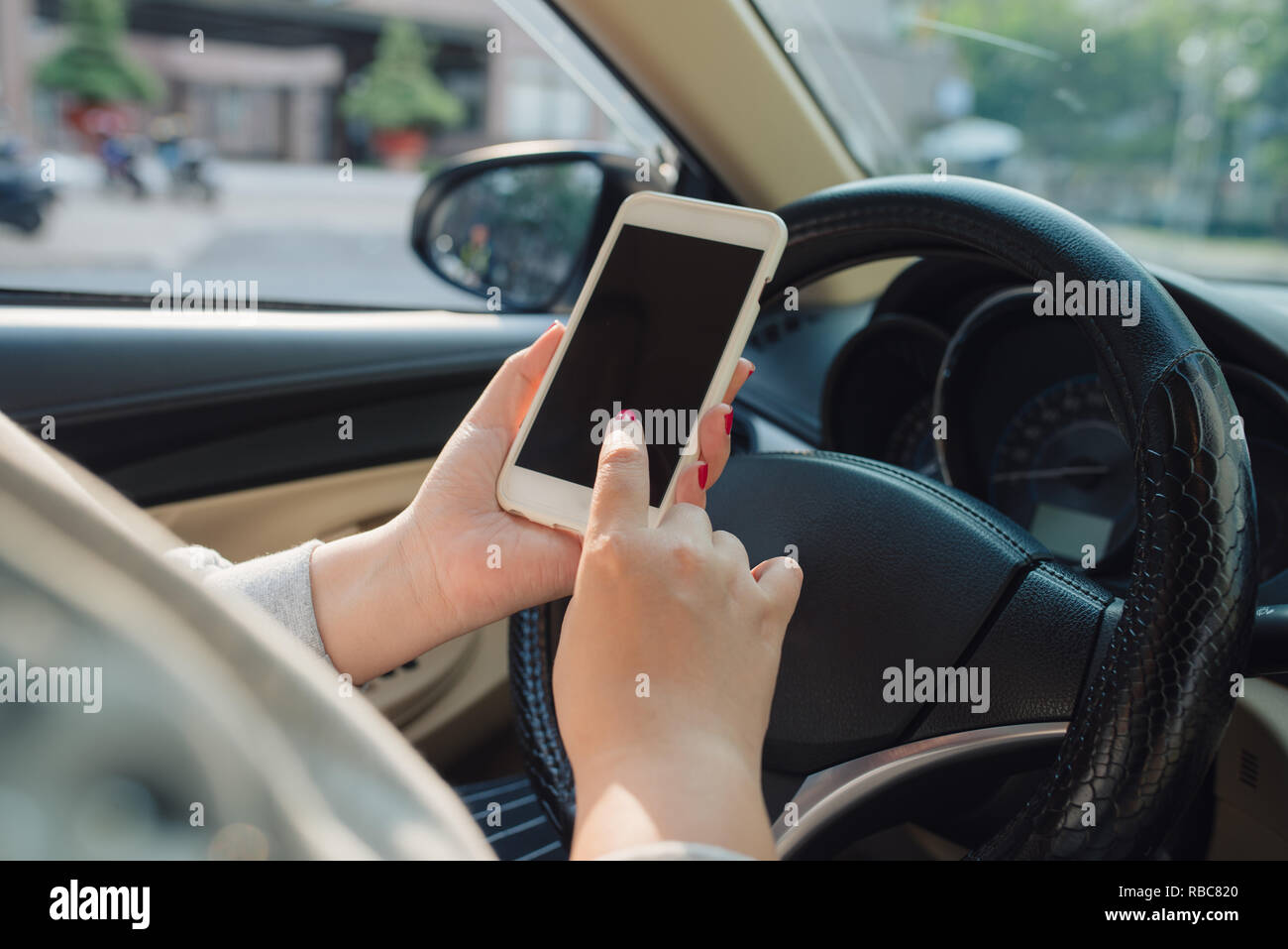 Young female driver using touch screen smartphone and hand holding ...