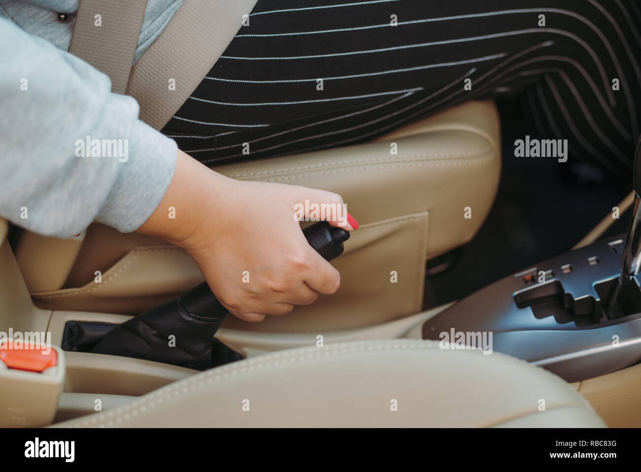 Woman driver pulling the hand brake in car Stock Photo - Alamy