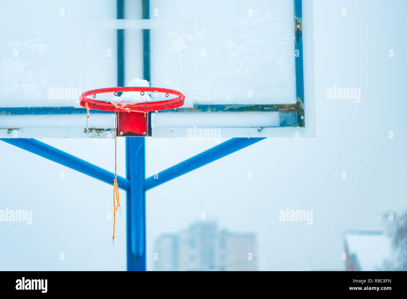 Frozen outdoor basketball hoop in winter snow on empty sport playground ...