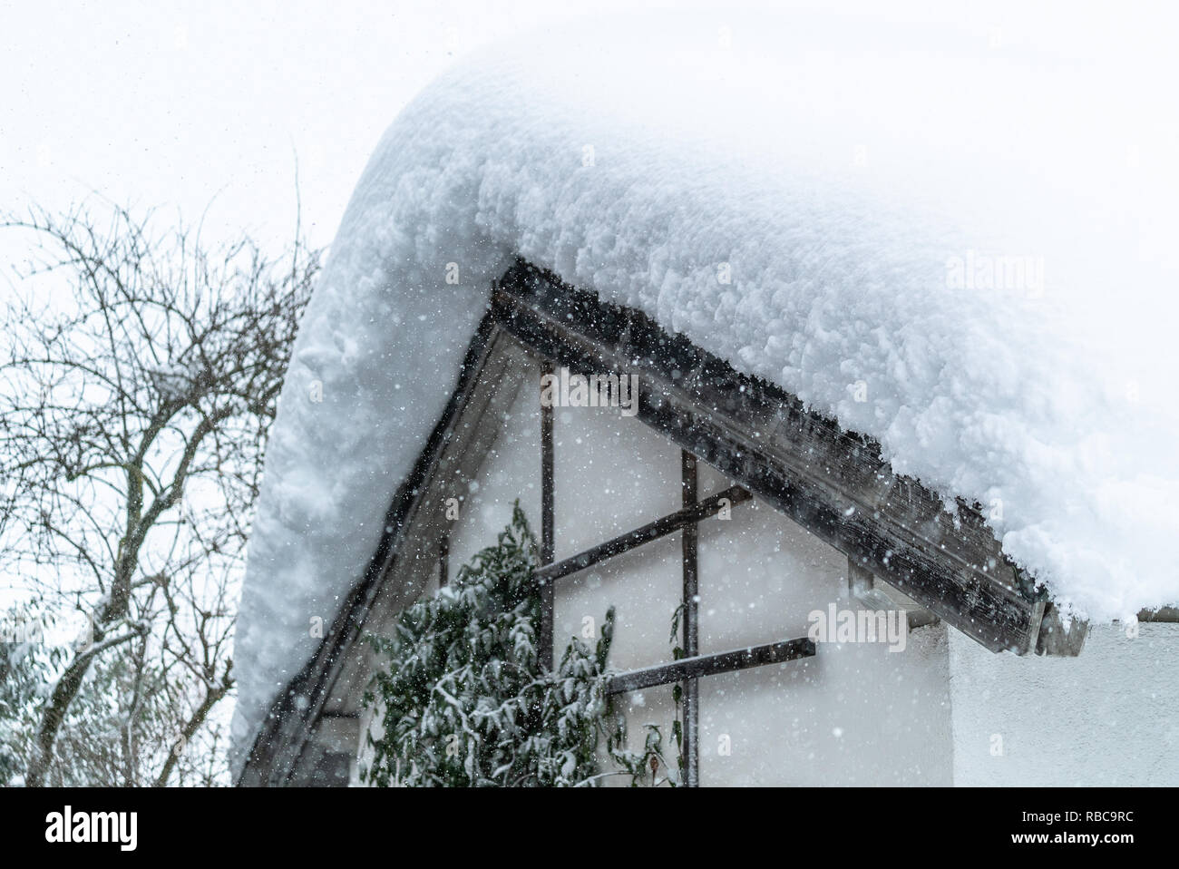 Snow drift on roof after two days of snowfalls. Thick layers hanging on ...