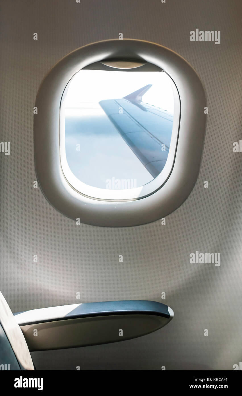 Plane interior sit and window. Airplane wing seen through the window ...