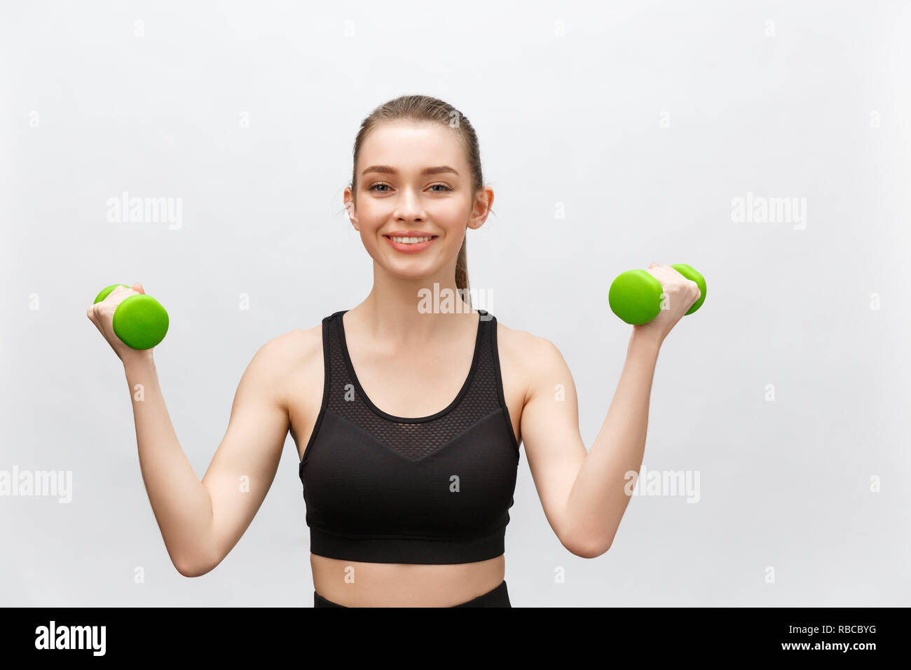 Happy fitness woman lifting dumbbells smiling cheerful, fresh and ...