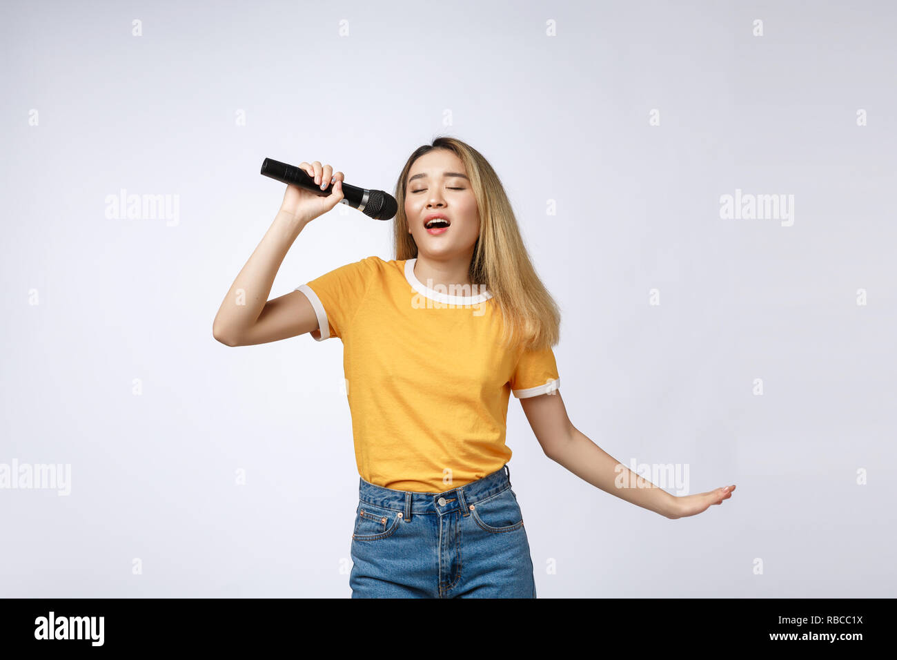 Beautiful asian woman sing a song to microphone, portrait studio on ...