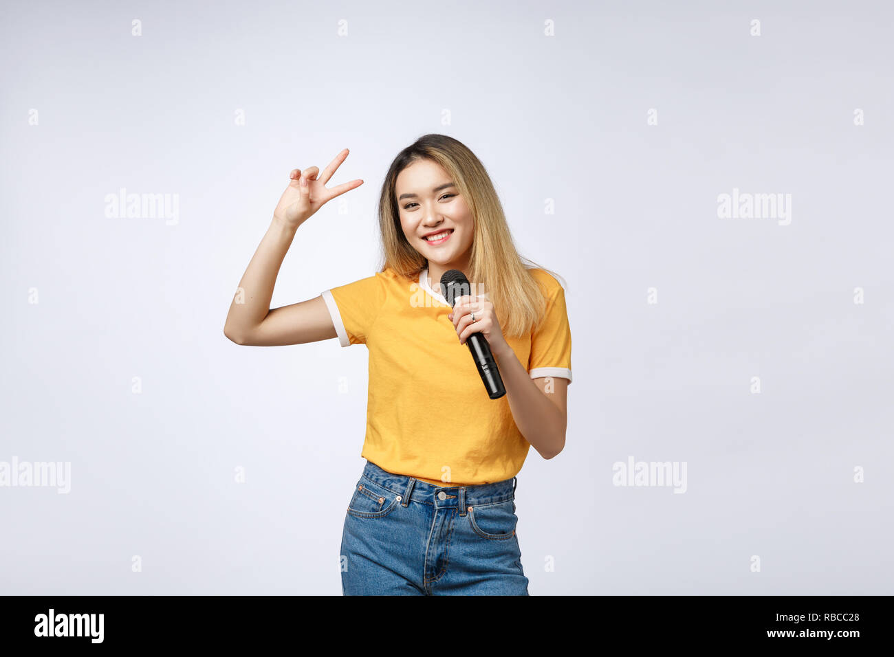 Beautiful asian woman sing a song to microphone, portrait studio on ...